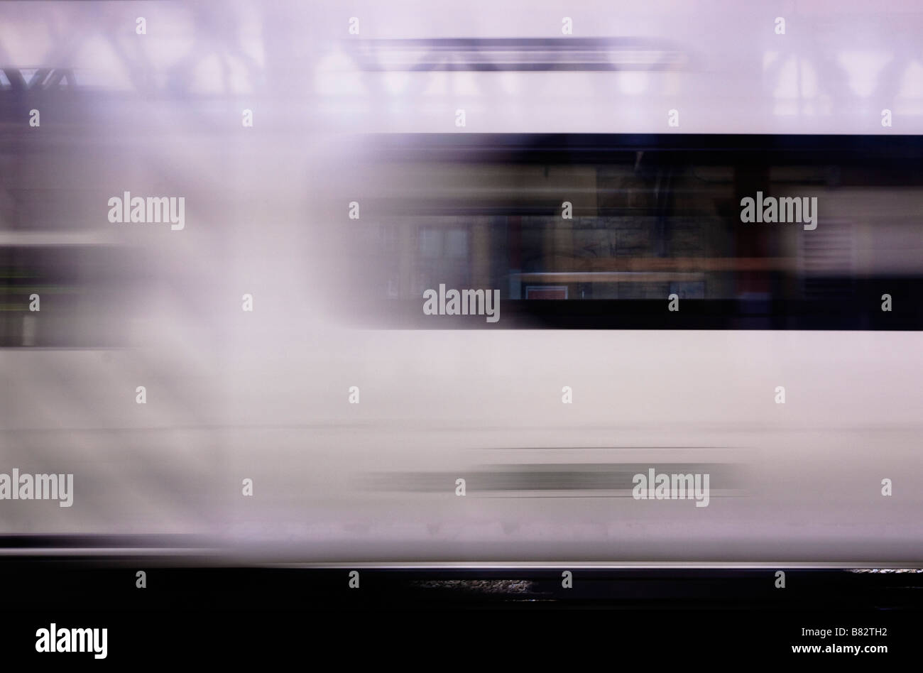 Speeding train going through station Stock Photo - Alamy