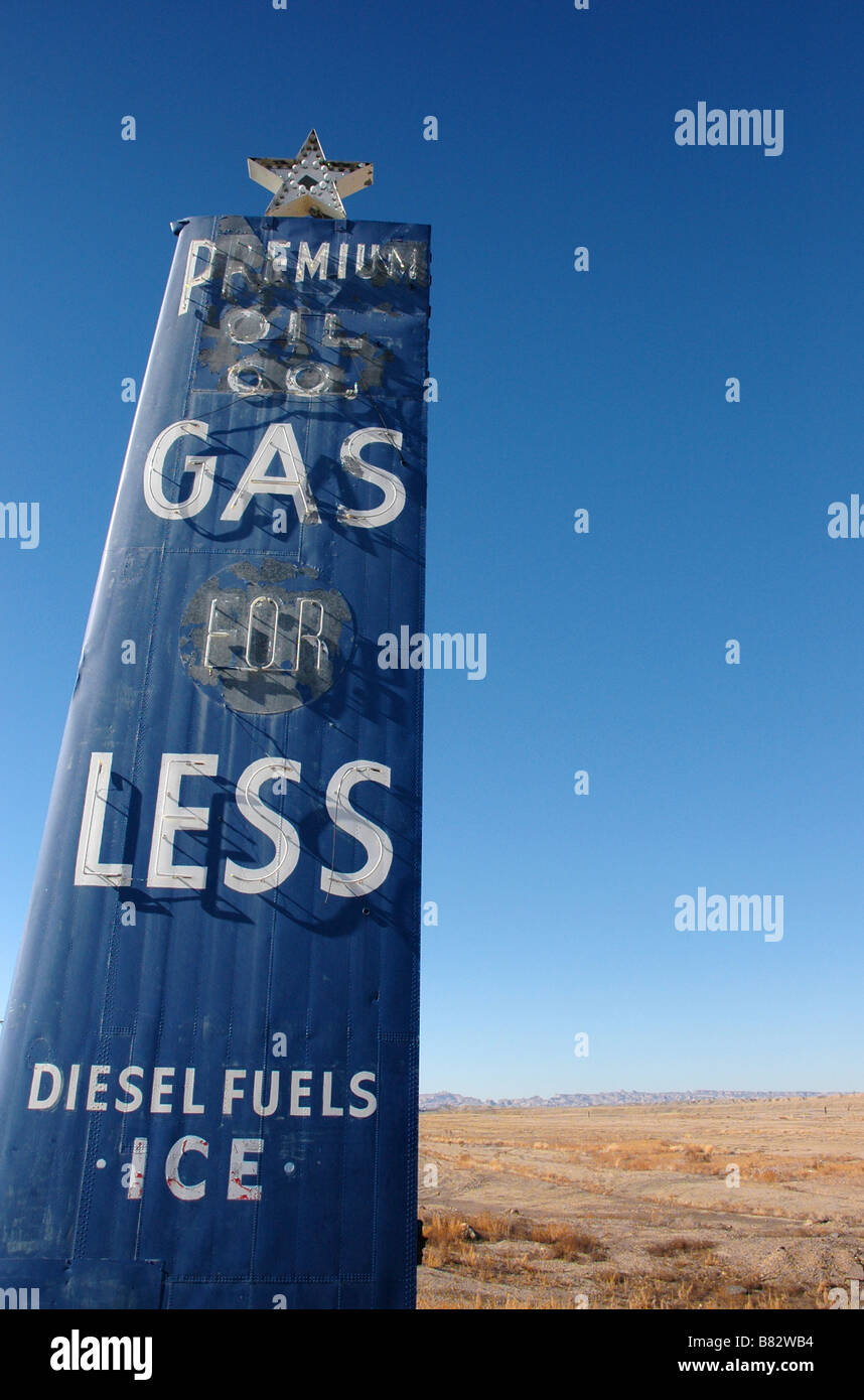 A broken old sign, outside a derelict gas station in the middle of ...