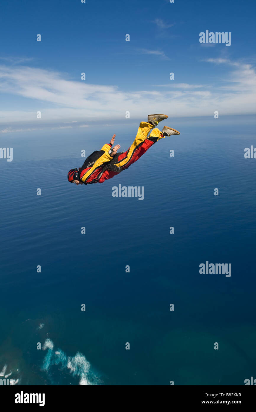 Skydiver is tracking along the blue sky into the deep blue ocean. Speed ...