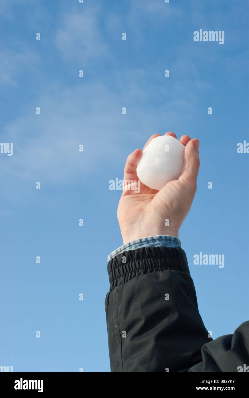Hand holding snowball, ready to throw Stock Photo - Alamy