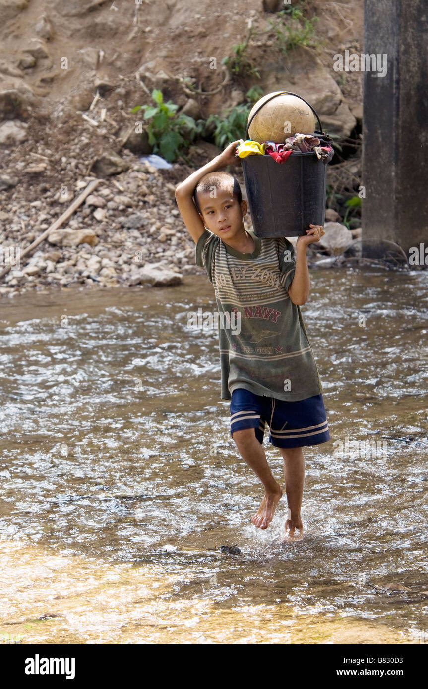 Refugee boy carrying clothes and his ball on his sholder hi-res stock ...