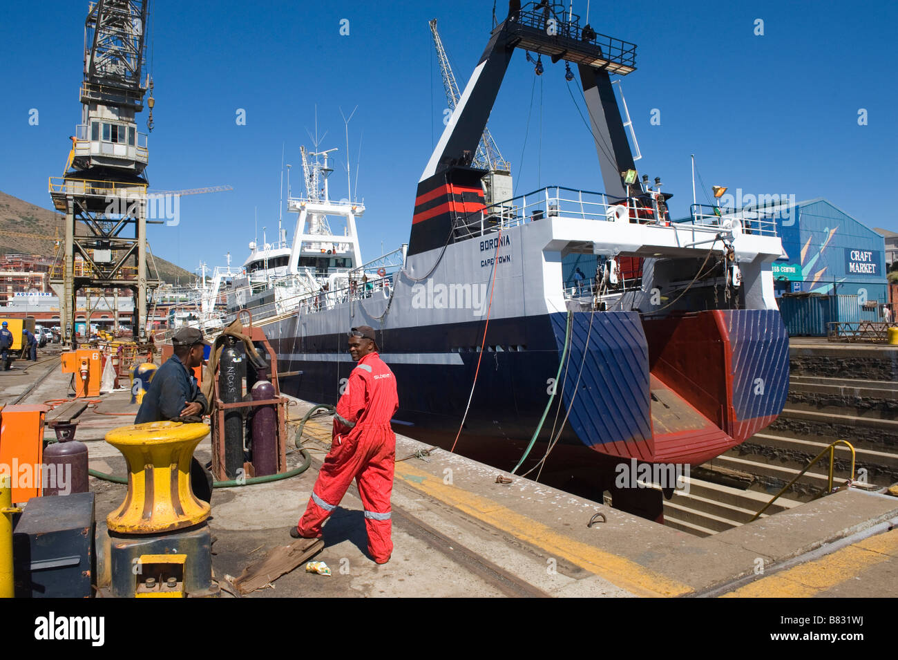 Workers and a fish trawler in a dry dock in Cape Town South Africa ...