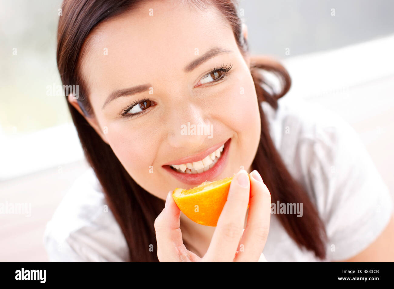 Girl eating orange Stock Photo - Alamy
