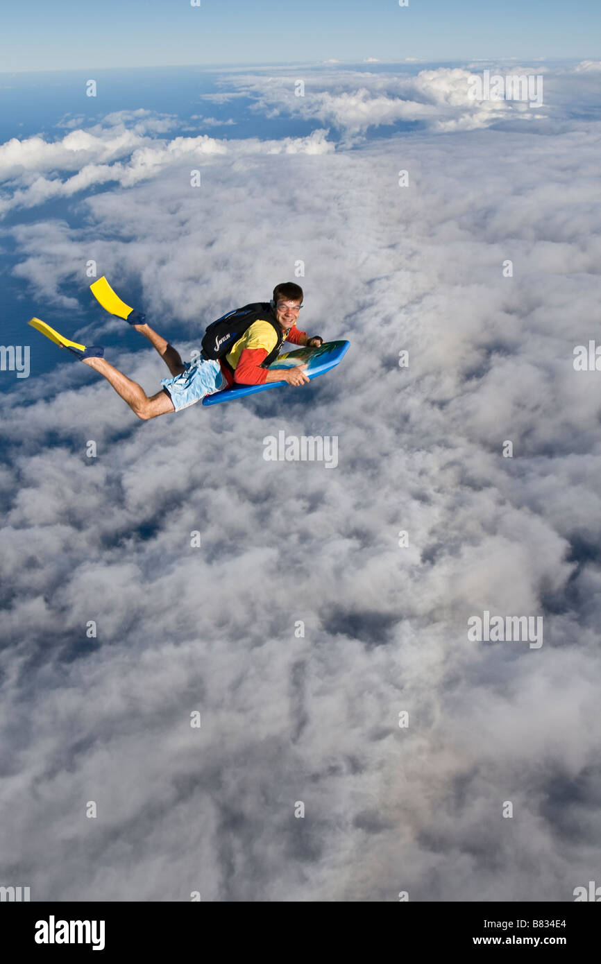 Skydiver is riding the big wave in the sky with a body board over the ...