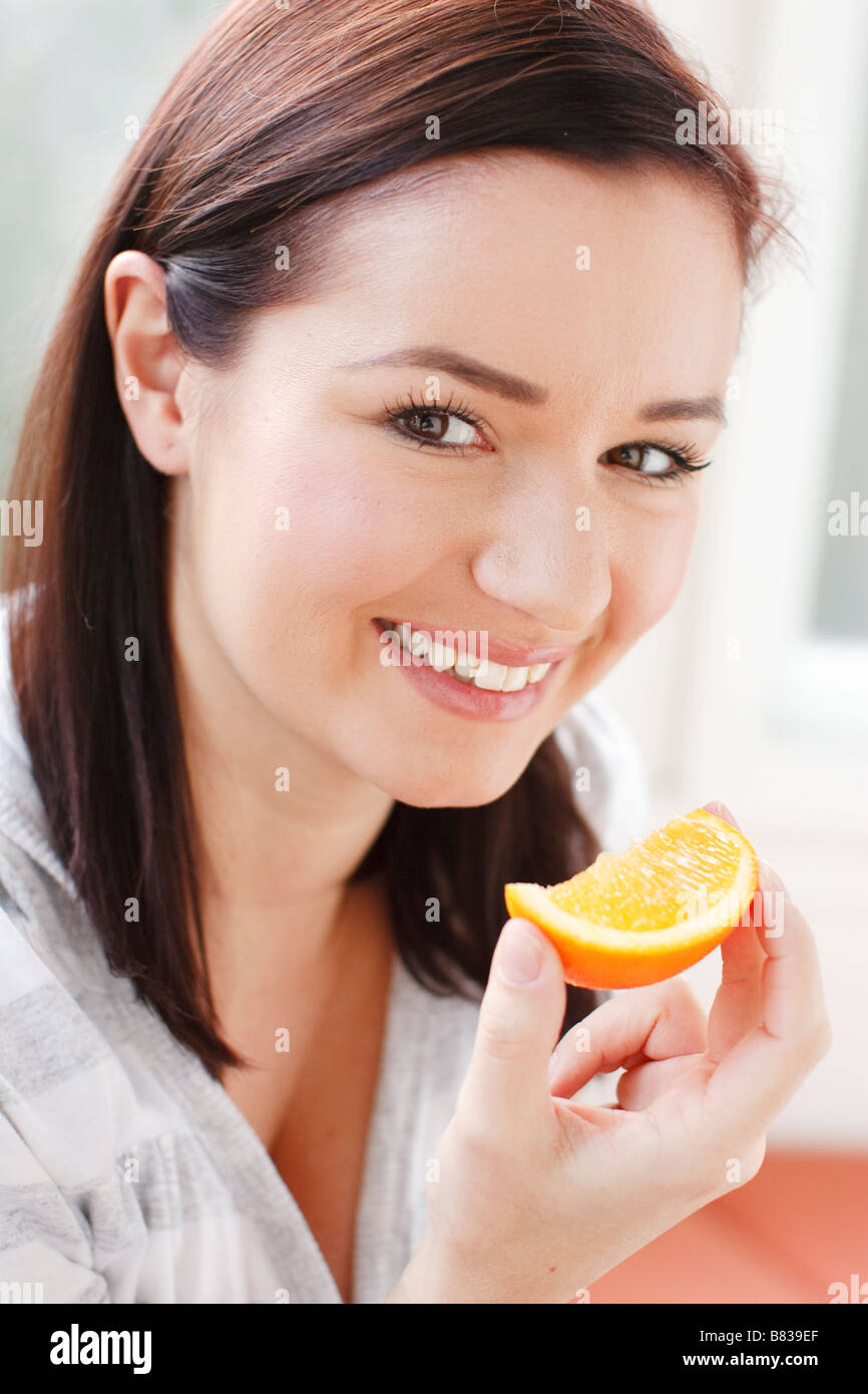 Girl eating orange Stock Photo - Alamy