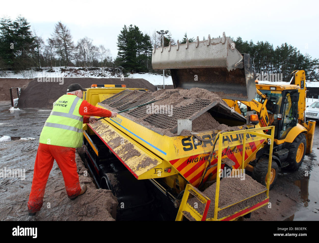 Gritters and snow ploughs being loaded with road grit at council roads ...