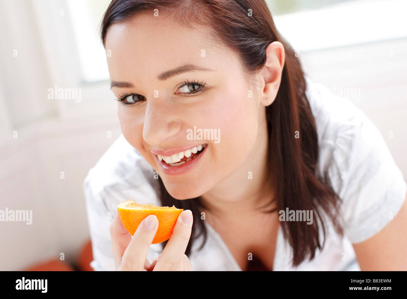 Girl eating orange Stock Photo - Alamy