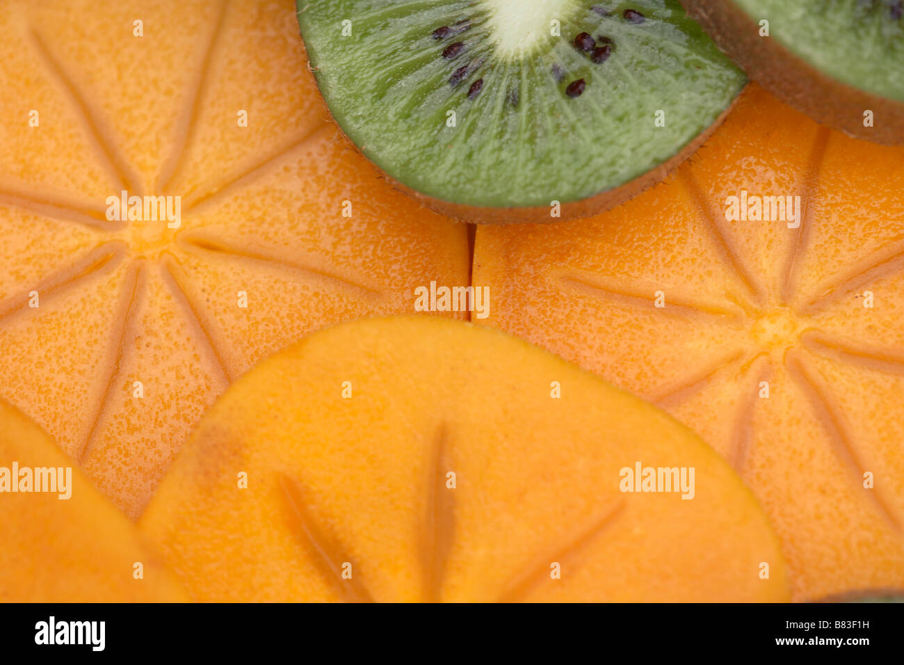 sliced sharon and kiwi fruit Stock Photo - Alamy