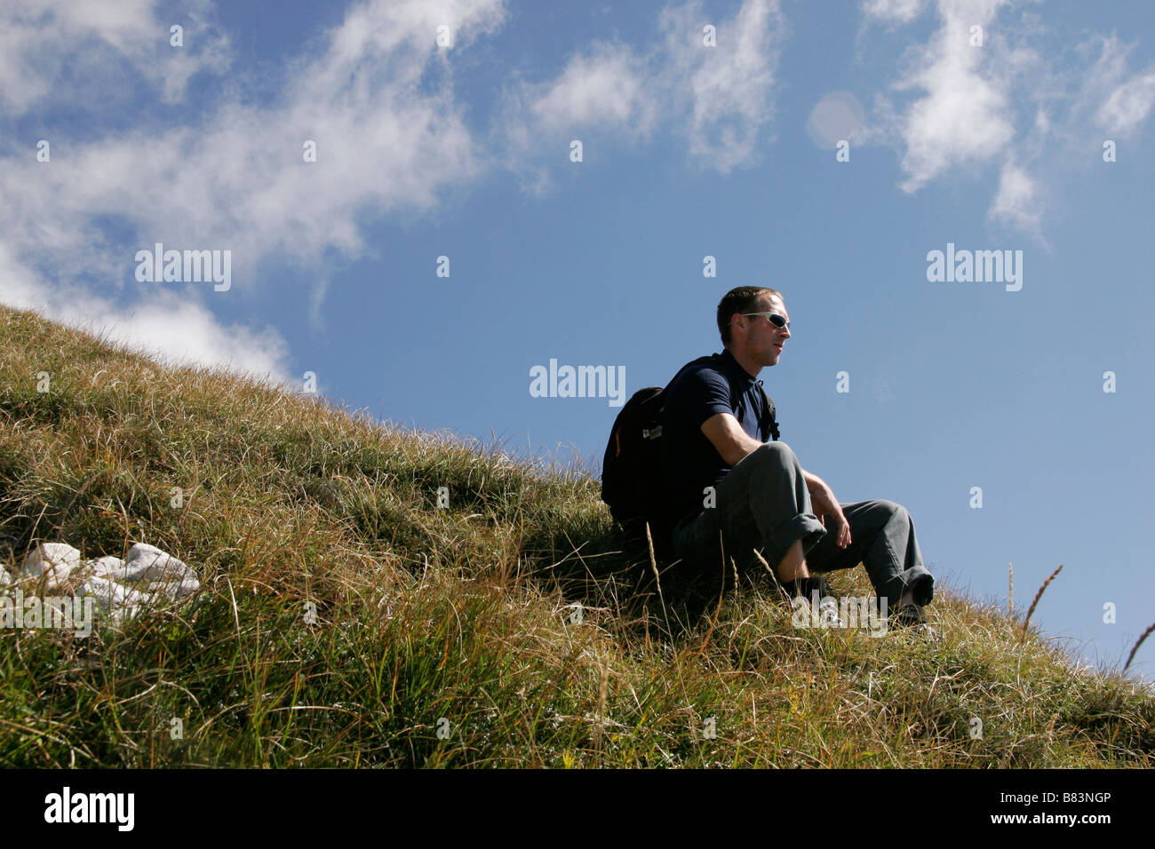 A hiker rests on the ridge on the Veliki vrh hike in the Karavanke ...