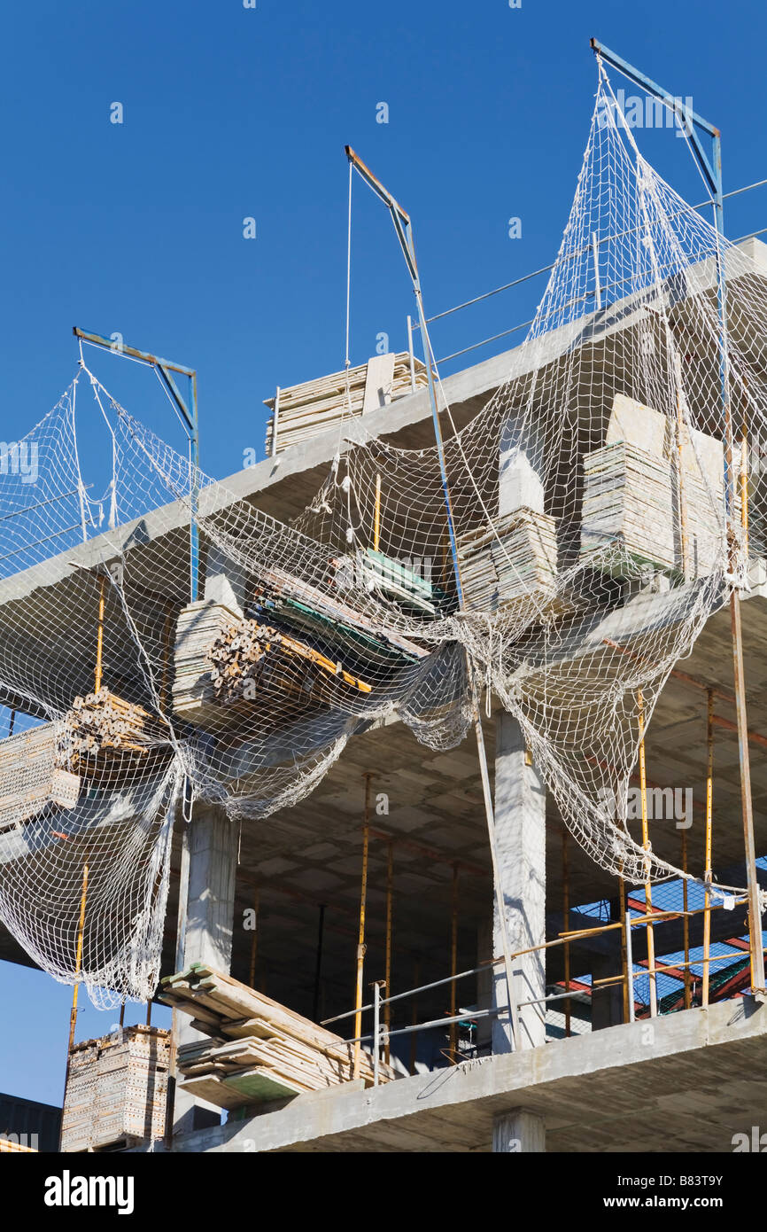Building under construction with safety netting against falling debris ...