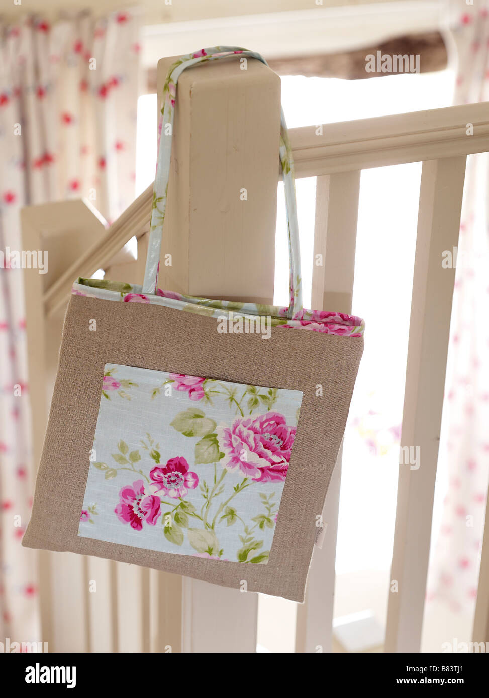 small bag with flower detail hung over the banister rail Stock Photo ...