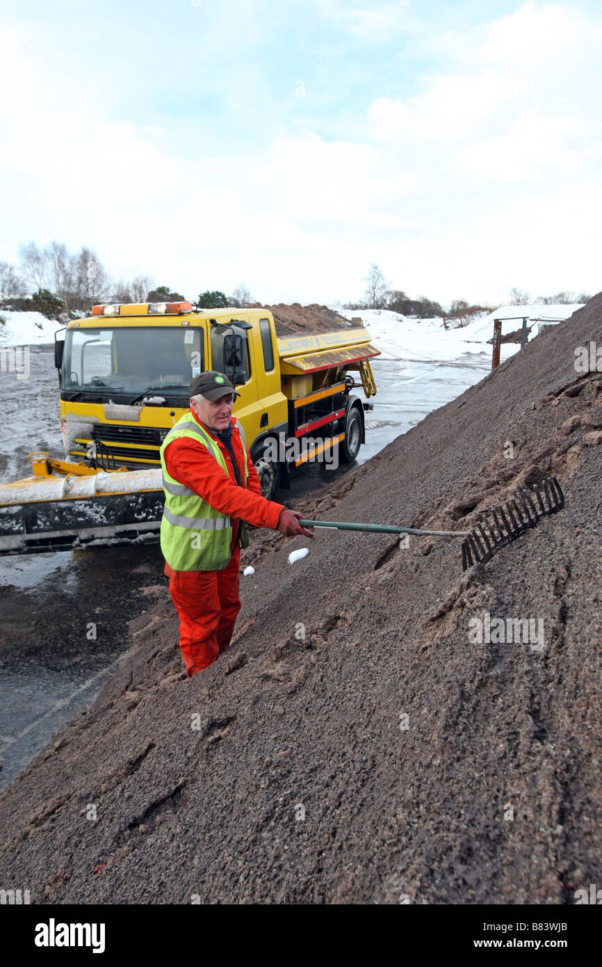 Gritters and snow ploughs being loaded with road grit at council roads ...