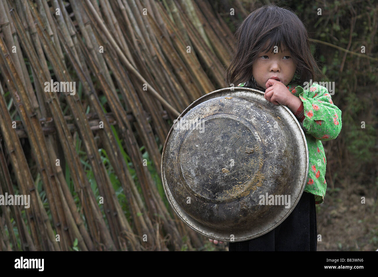 Vietnamese child holding a large pan Stock Photo - Alamy