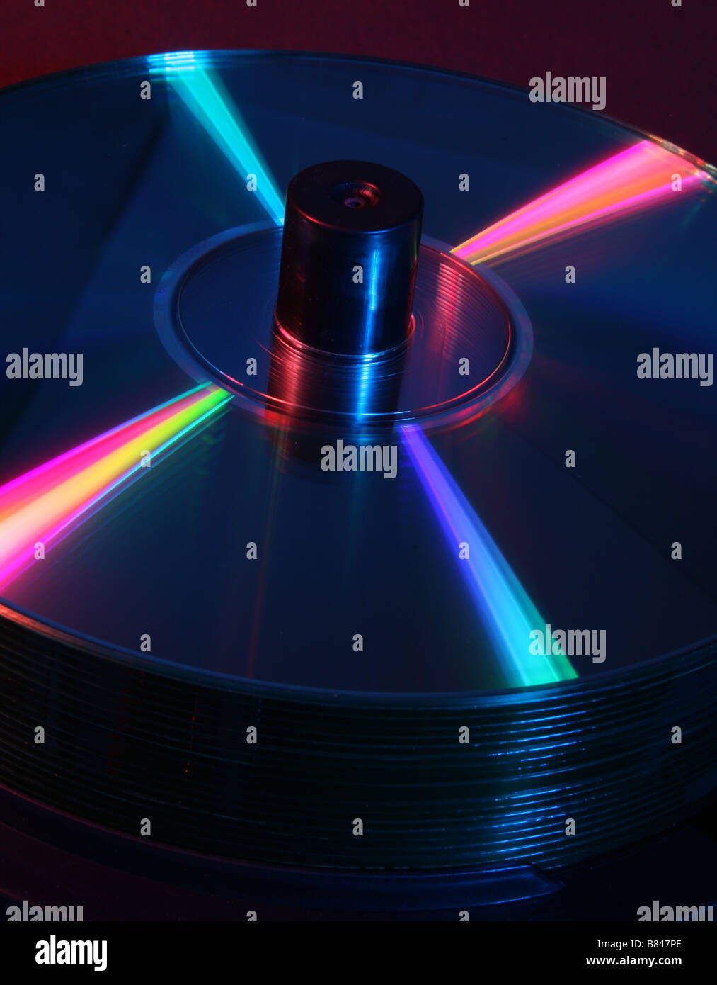stack of CD's on a spindle lit with red and blue studio lighting Stock ...
