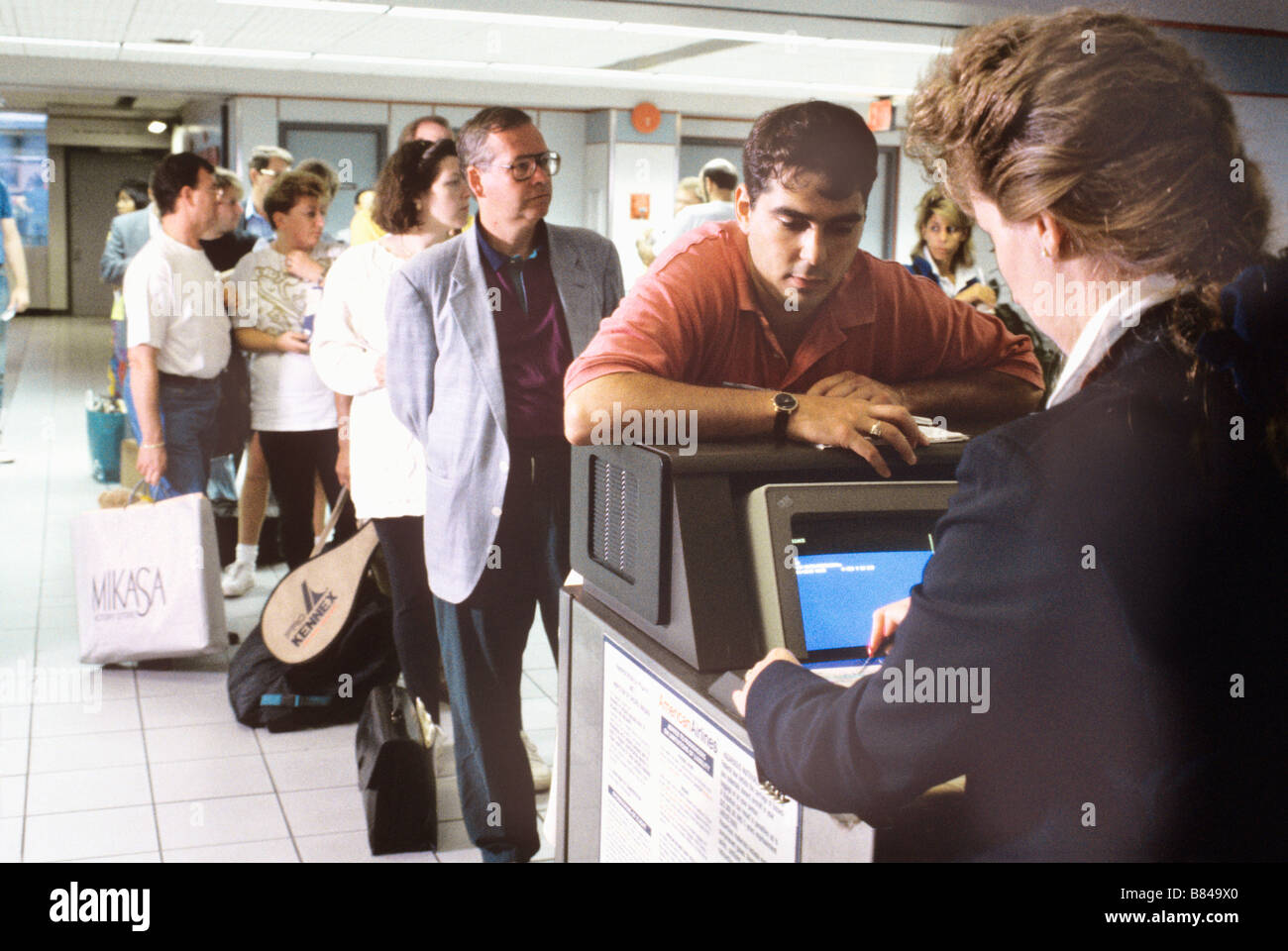 People waiting in line at airline ticket counter Stock Photo - Alamy