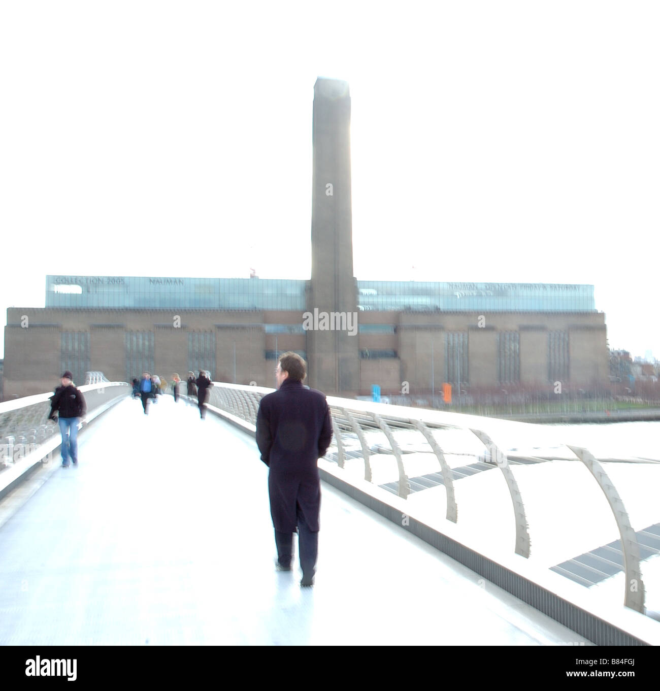 Tourists walking over Millennium Bridge with Tate Modern in background ...