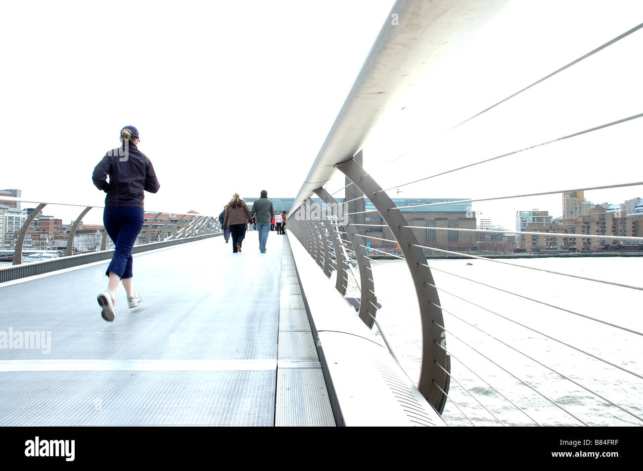 Runner crossing over Millennium Bridge Stock Photo - Alamy