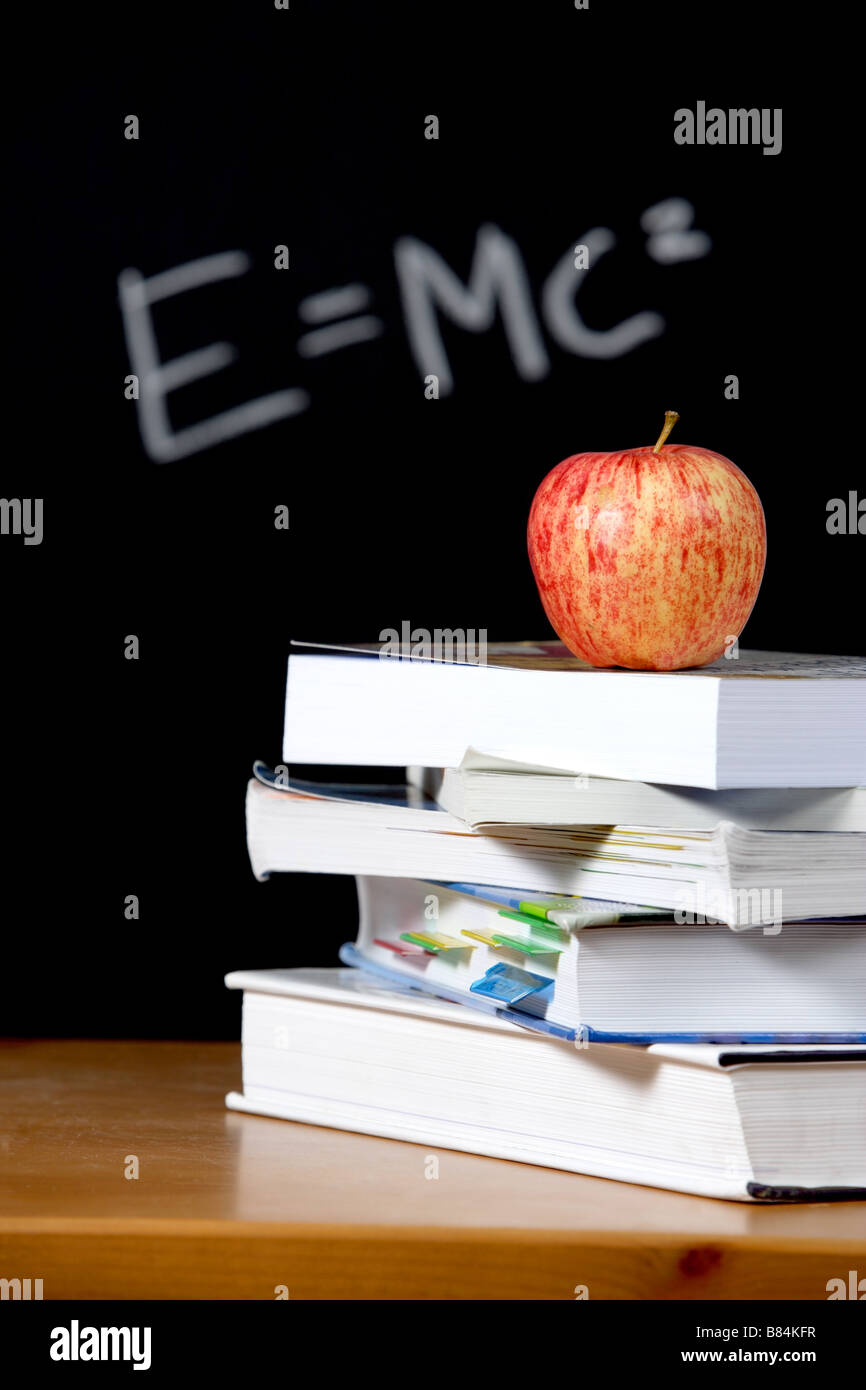 An apple on a stack of books on the teachers desk Stock Photo - Alamy