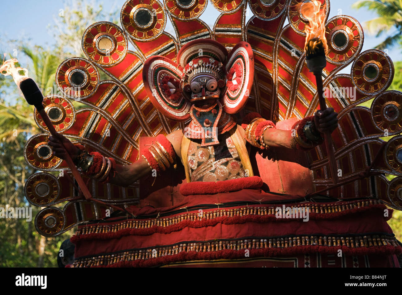 A fully dressed up theyyam trance dancer during his performance of an ...