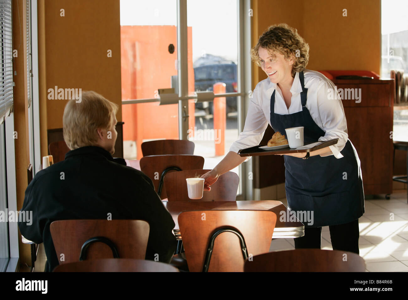 Waitress serving coffee Stock Photo - Alamy
