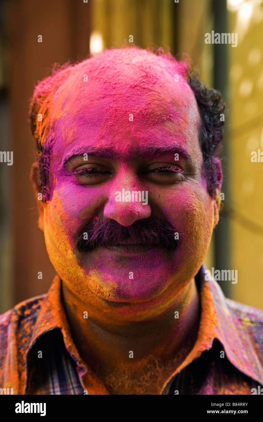 Smiling old man covered on coloured powder at the Holi festival in ...