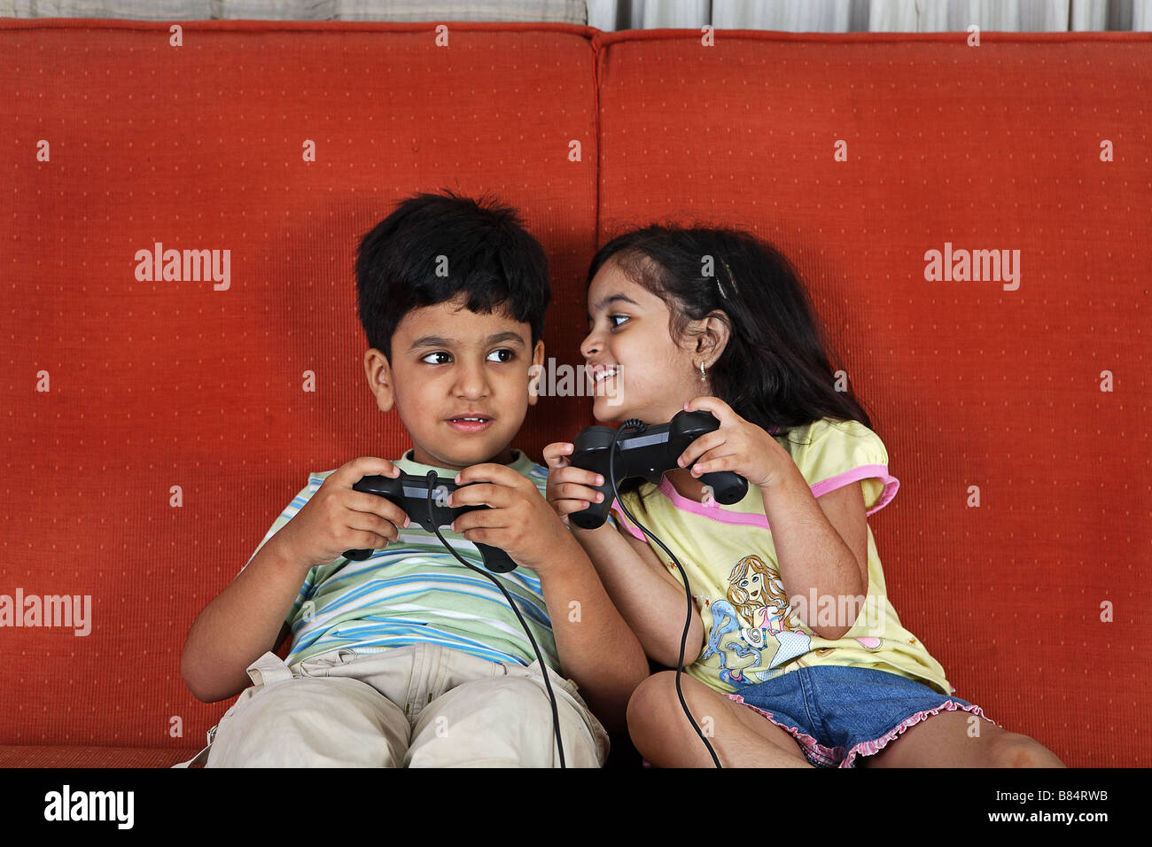 Young children playing video games in a playful mood Stock Photo - Alamy