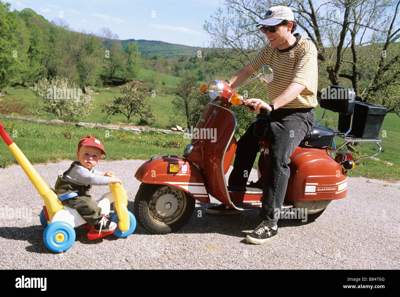 Man with vespa and baby Stock Photo - Alamy