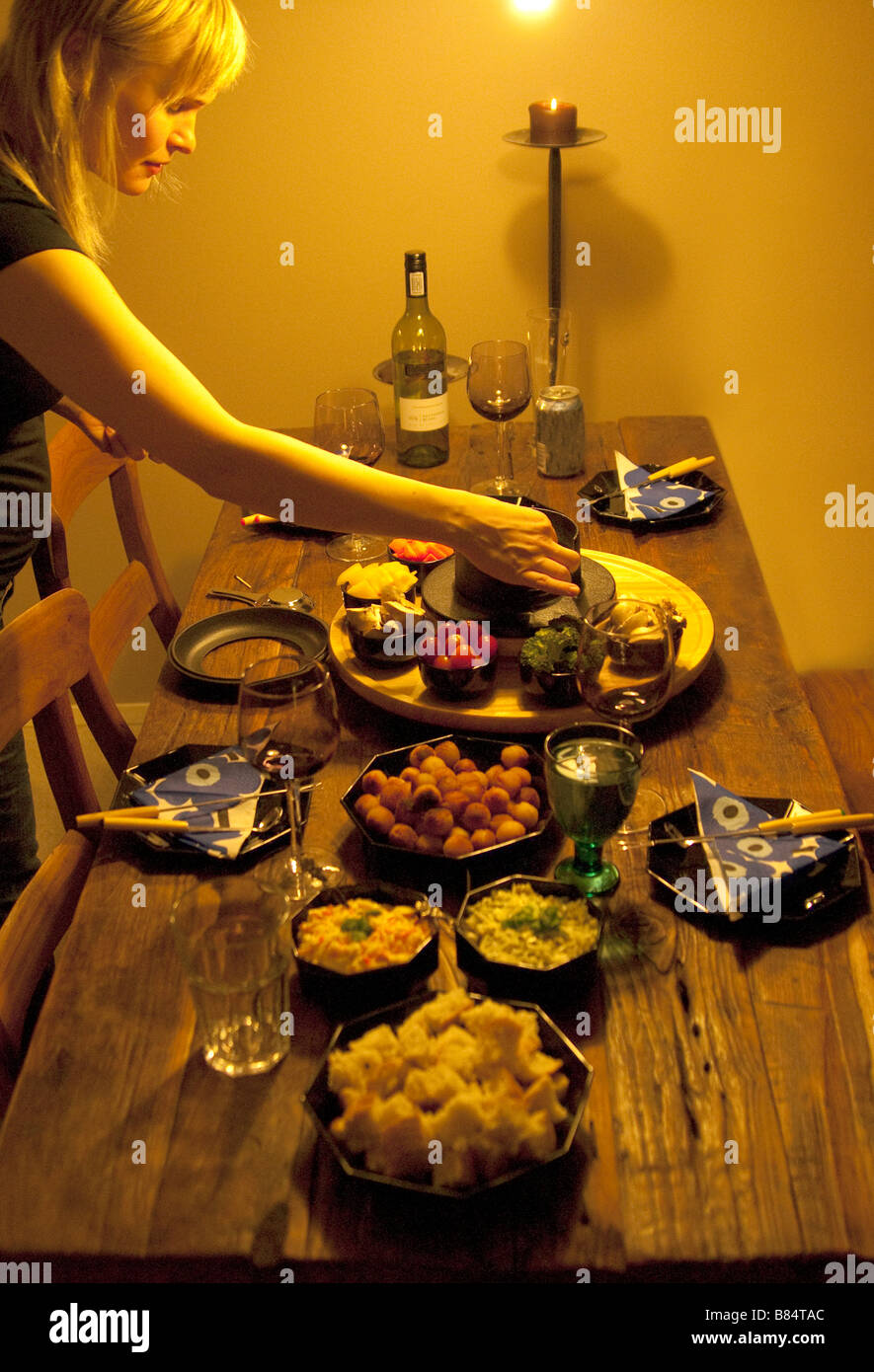 Attractive young woman preparing the dinner table for a dinner Stock ...