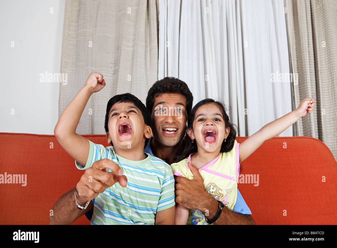 Young children rejoicing with their father Stock Photo - Alamy