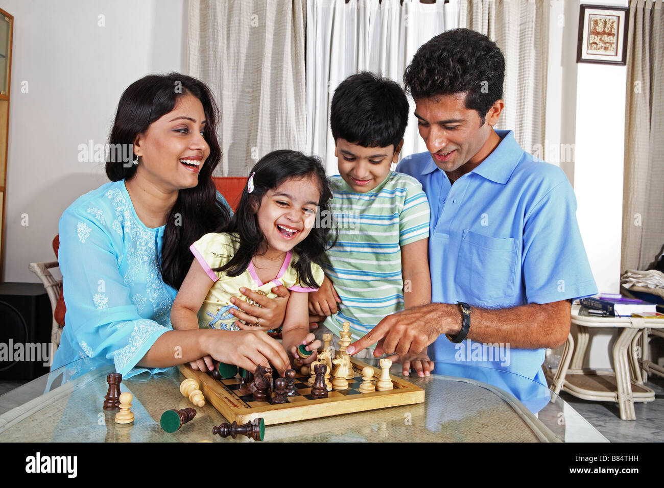 A family playing a game of chess Stock Photo - Alamy