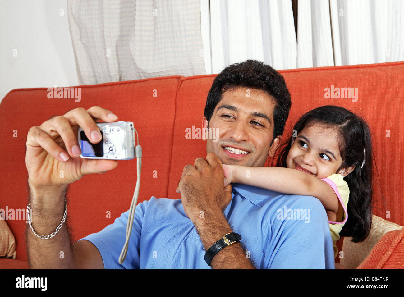 Father and daughter clicking pictures of themselves with a digital ...