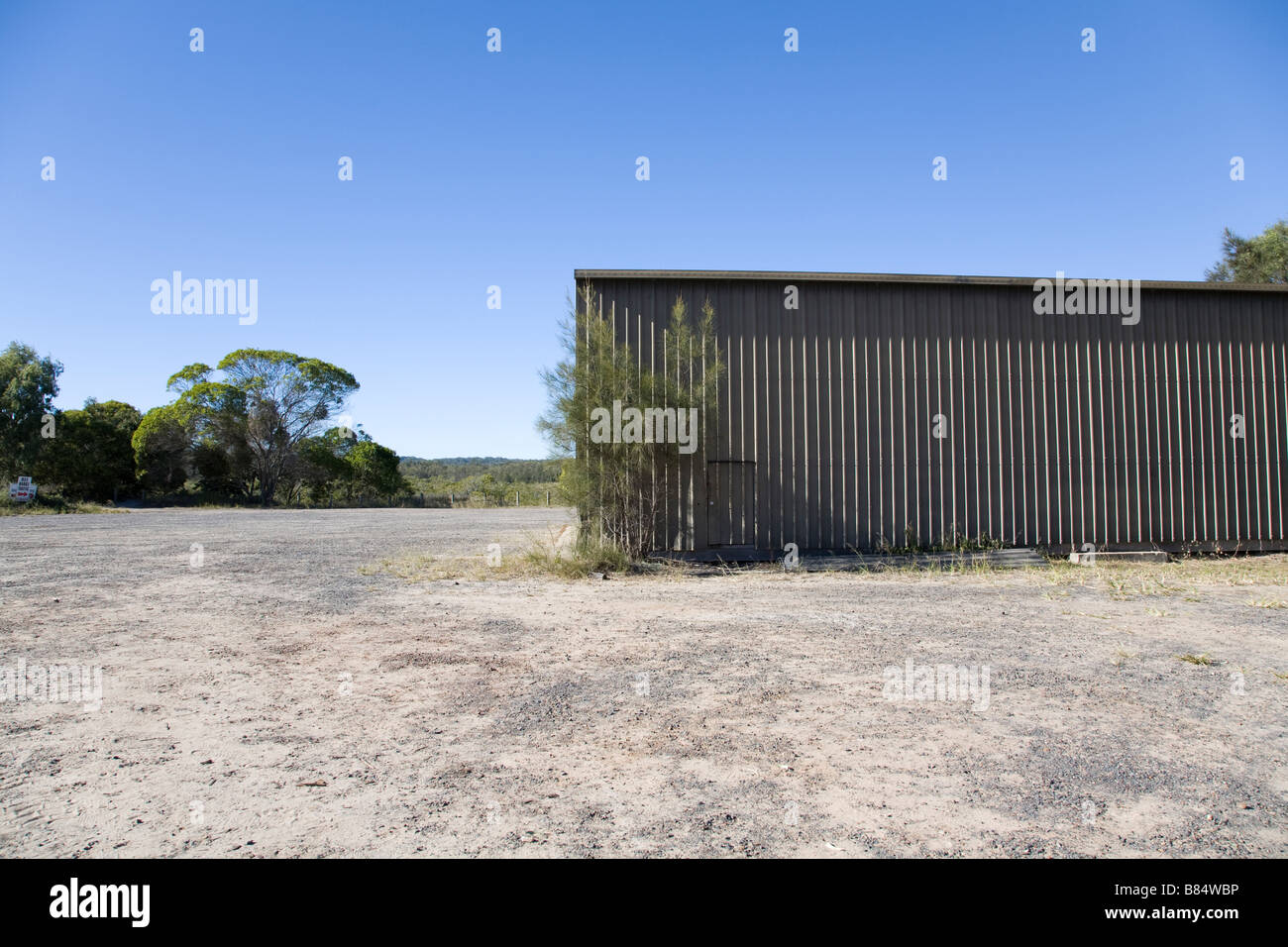warehouse in the sun with dusty ground Stock Photo - Alamy