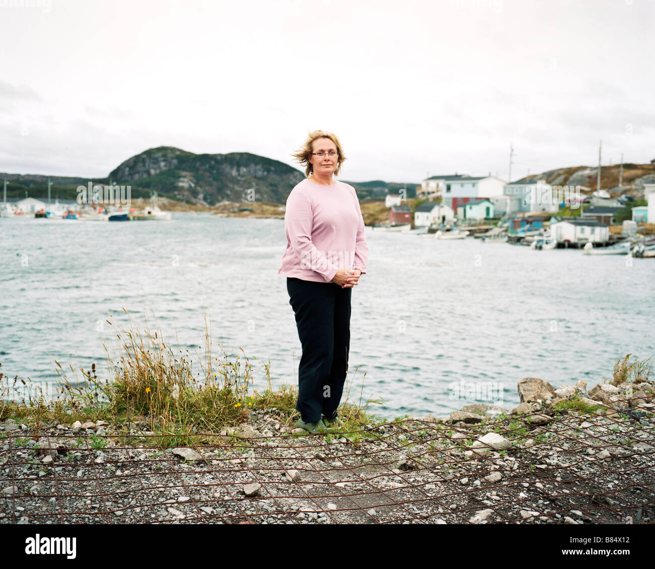 A woman poses for a portrait in front of her home in Burgeo ...