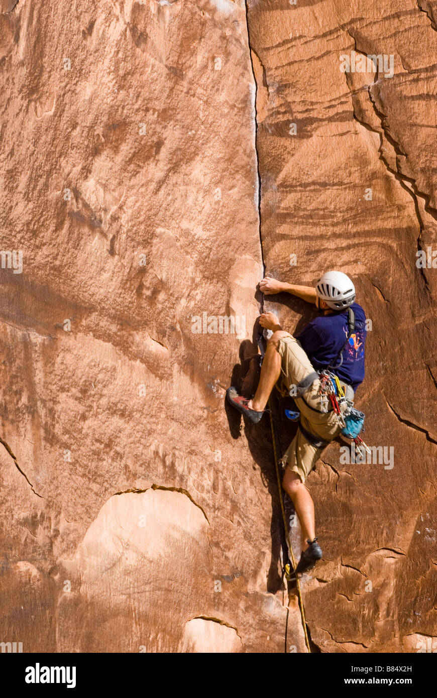 a rock climber ascending a sandstone wall near Moab Utah USA Stock ...