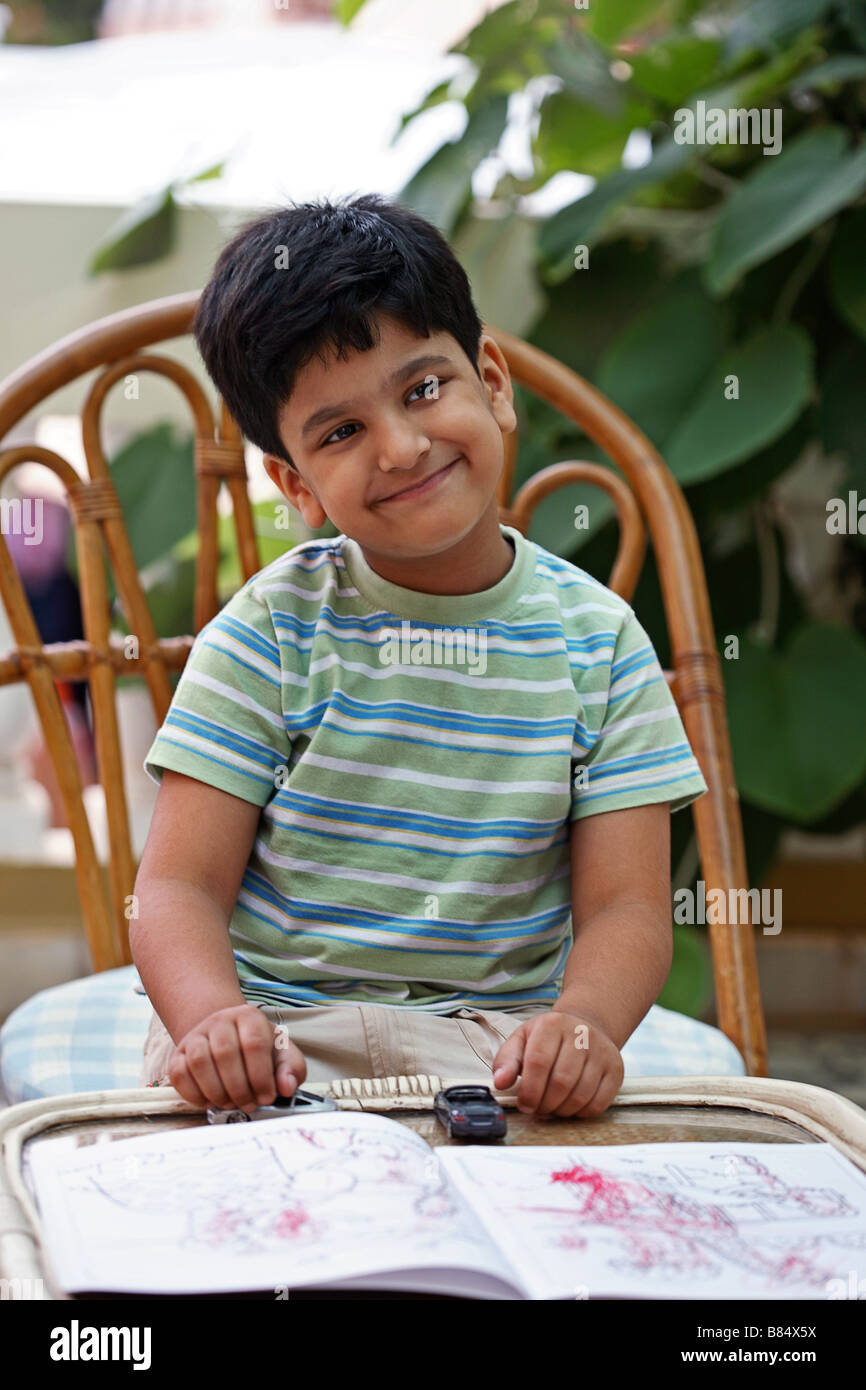 A young boy sitting on a chair Stock Photo - Alamy