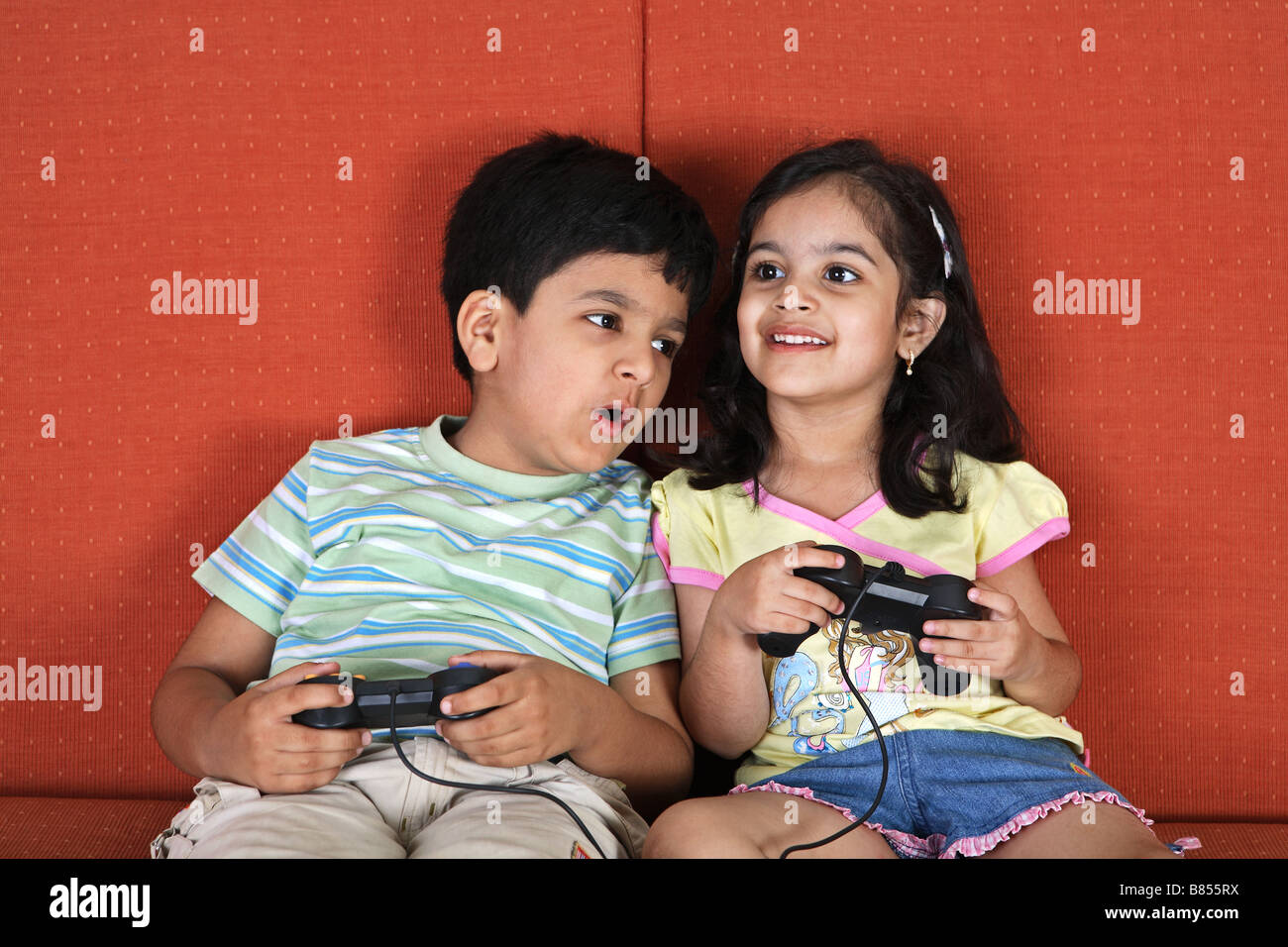 Young children playing video games in a playful mood Stock Photo - Alamy