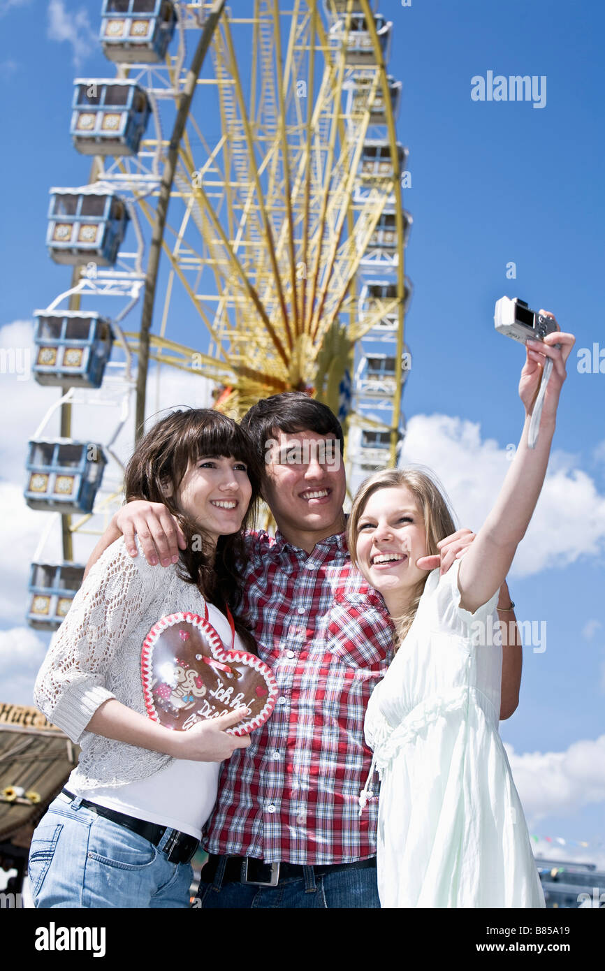 group of three friends at fun fair taking photo of themselves Stock ...