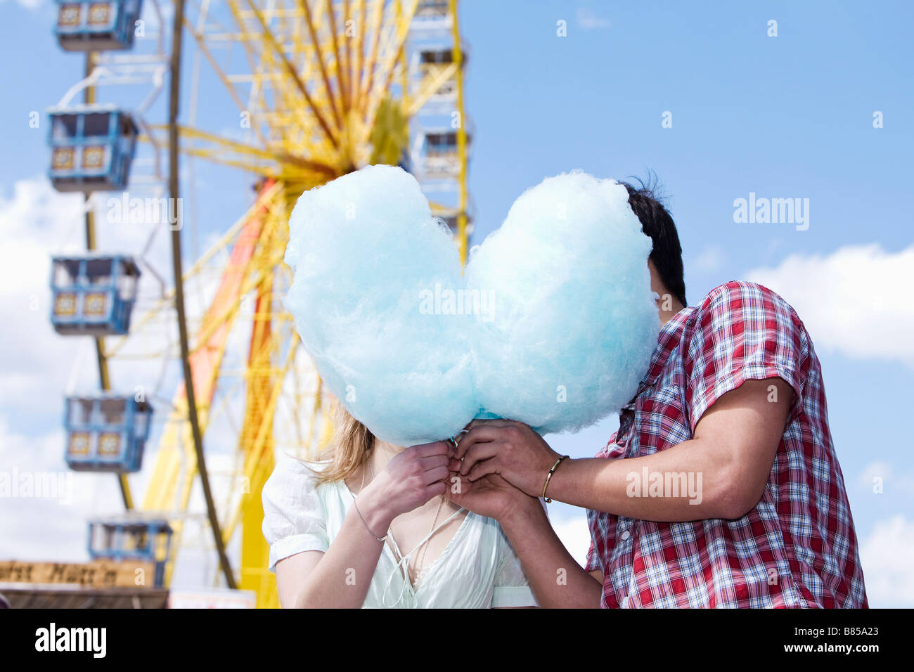 teenage couple sharing cotton candy at fun fair Stock Photo - Alamy