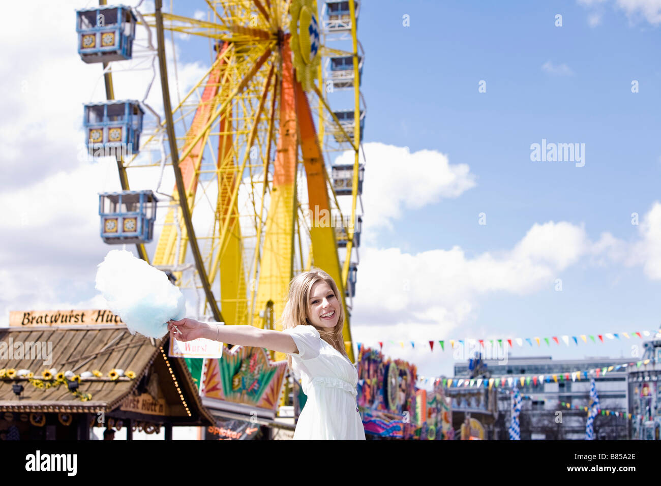 young woman at fun fair holding cotton candy Stock Photo - Alamy