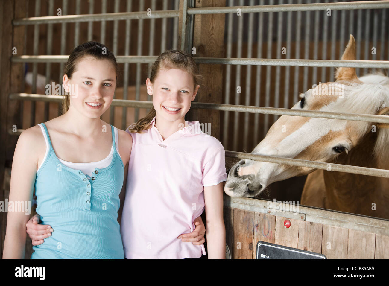 portrait of two girls in stable at horse ranch Stock Photo - Alamy