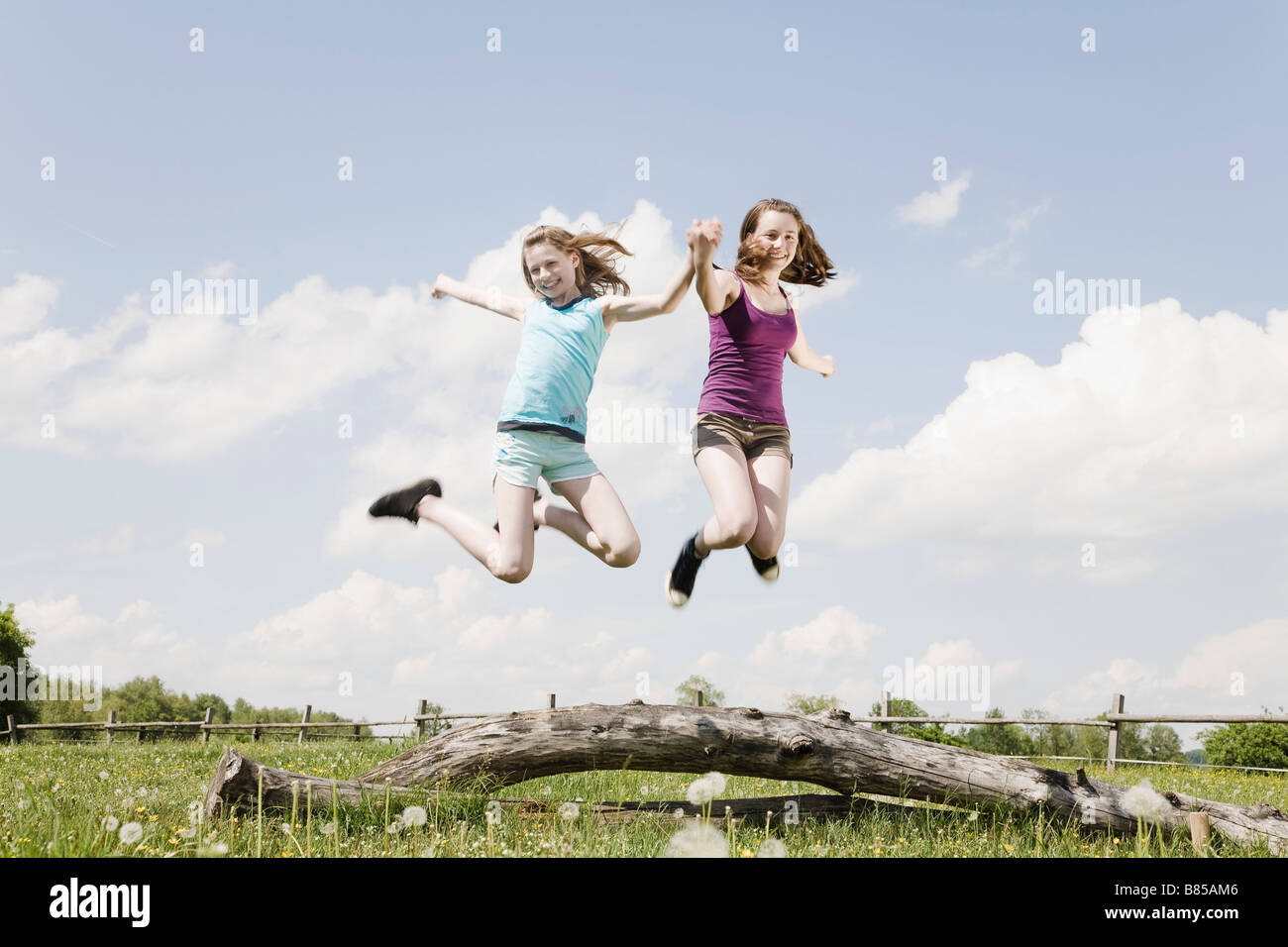 two girls jumping up in the air Stock Photo - Alamy