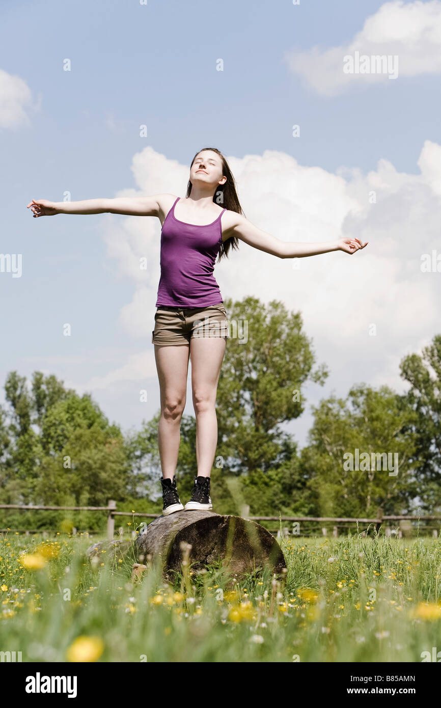 portrait of young girls balancing on tree trunk Stock Photo - Alamy