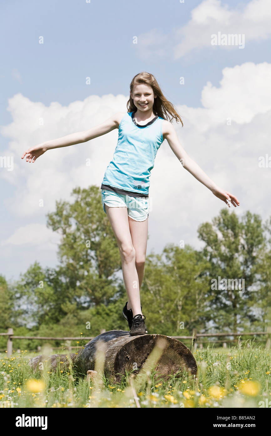 Young girl balancing tree trunk hi-res stock photography and images - Alamy