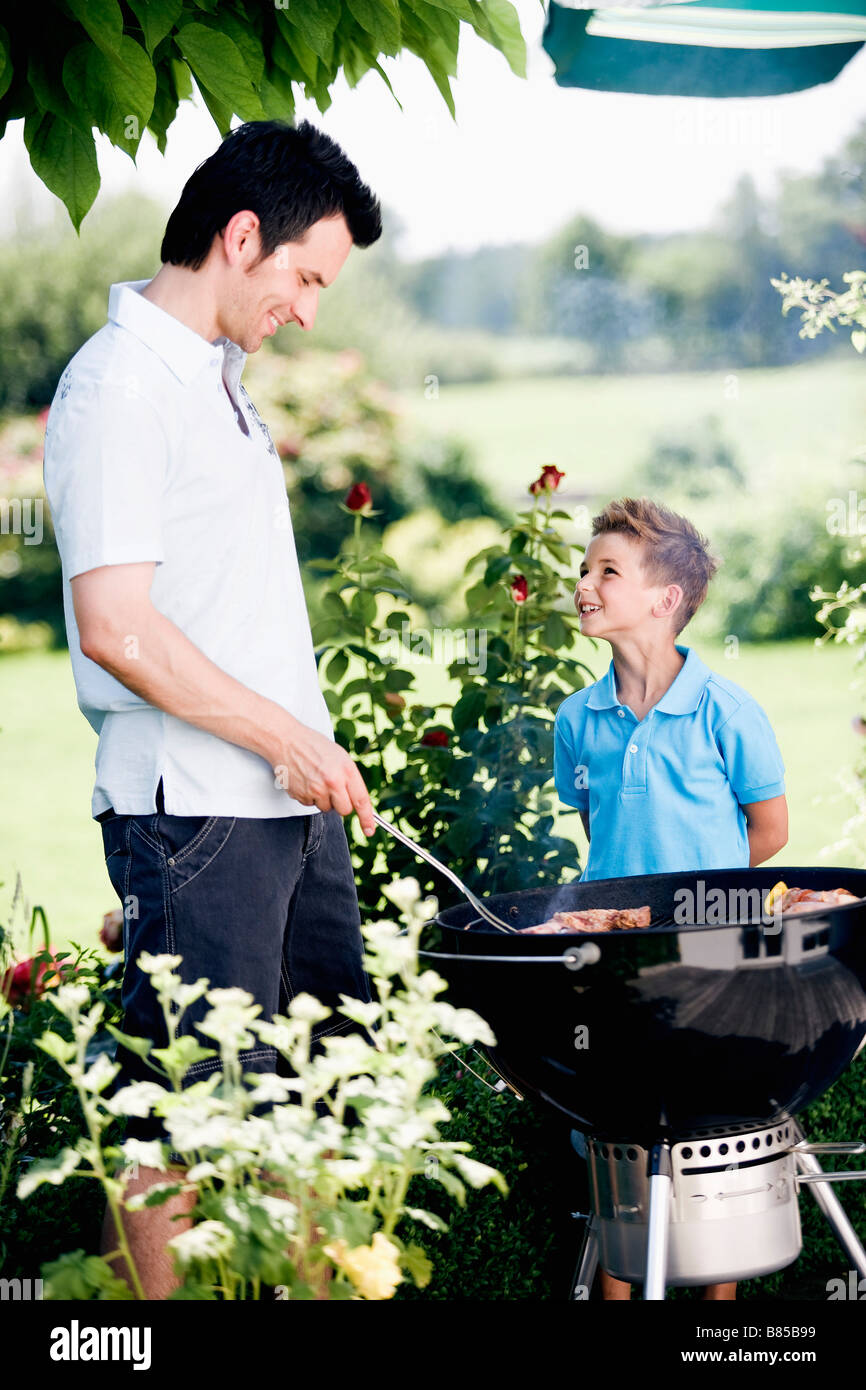 father and son grilling together at barbecue Stock Photo - Alamy
