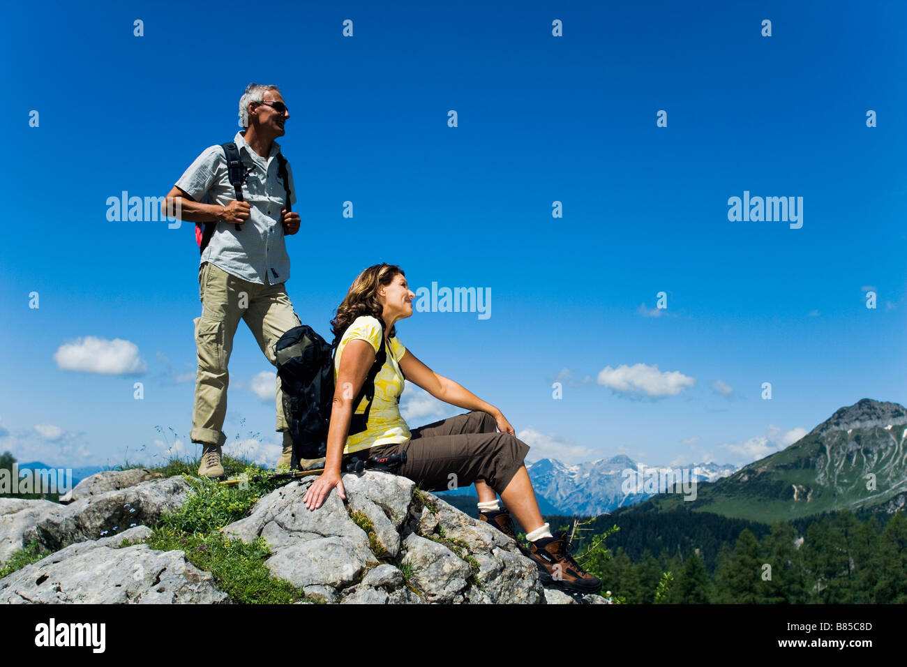 mature couple resting on rock in the mountains Stock Photo - Alamy