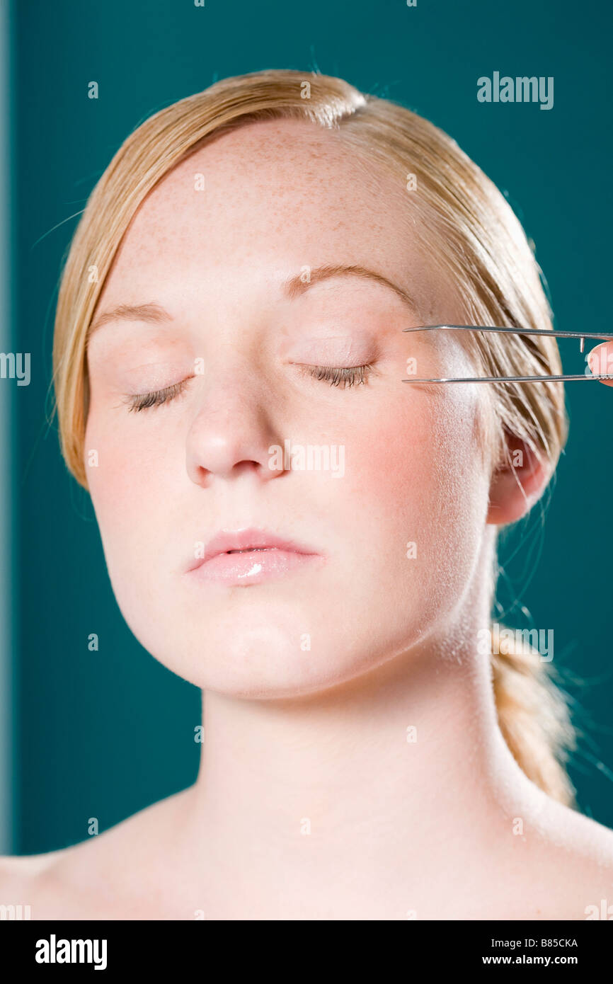 headshot of young woman with tweezers measuring face Stock Photo - Alamy