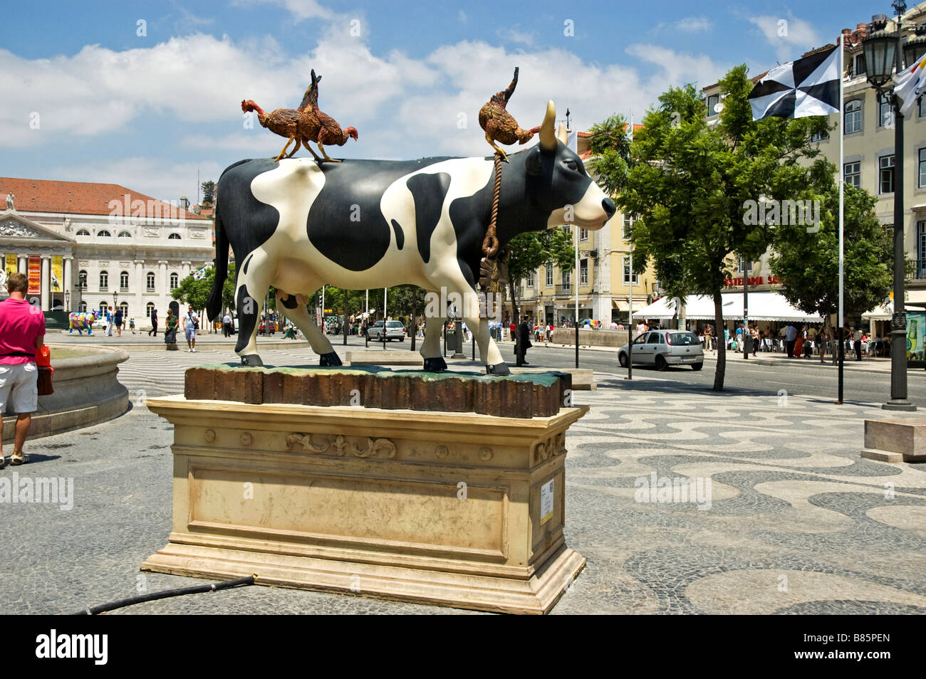 Chickens peck on the back of a full size black and white fibreglass cow ...