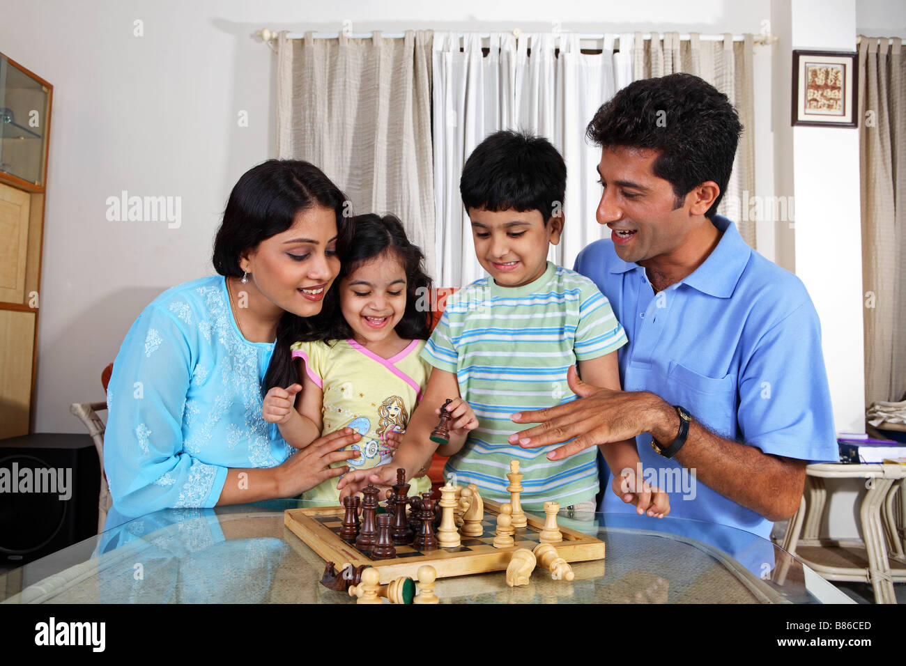 A family playing a game of chess Stock Photo - Alamy
