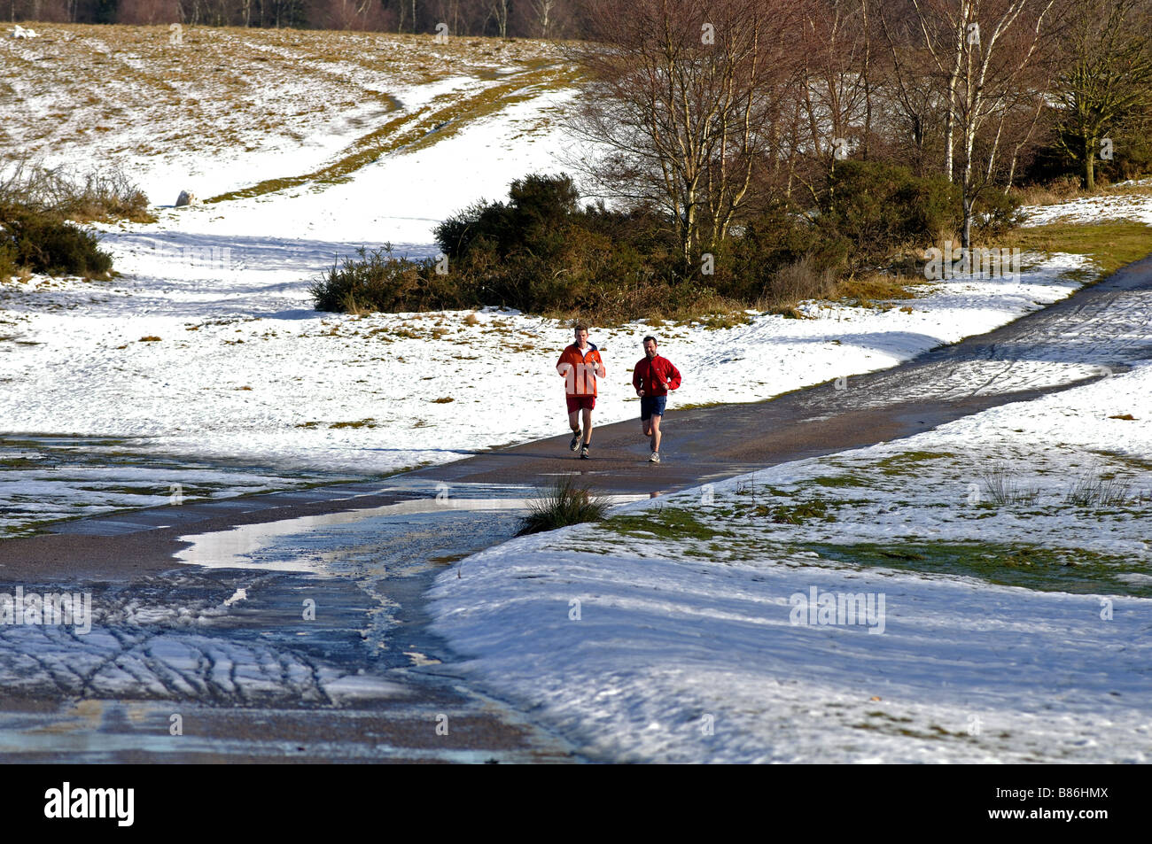 Two runners in Sutton Park in winter, West Midlands, England, UK Stock ...