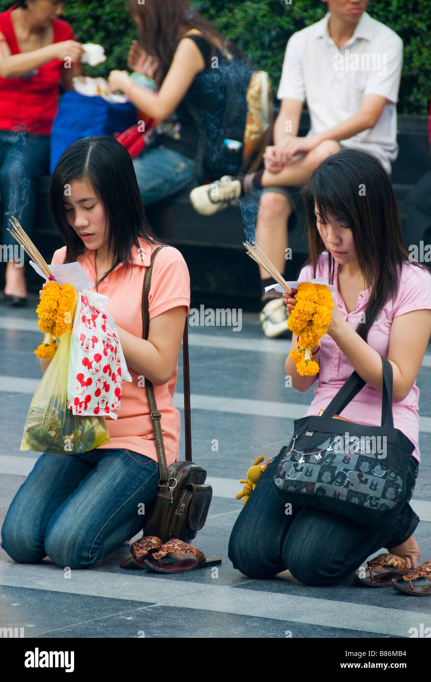 young women praying for true love at the Phra Trimurti God of Love ...